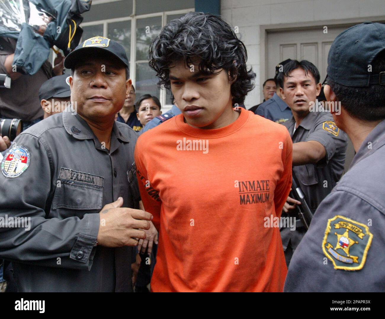 A handcuffed member of the extremist Abu Sayyaf Group is led to a ...