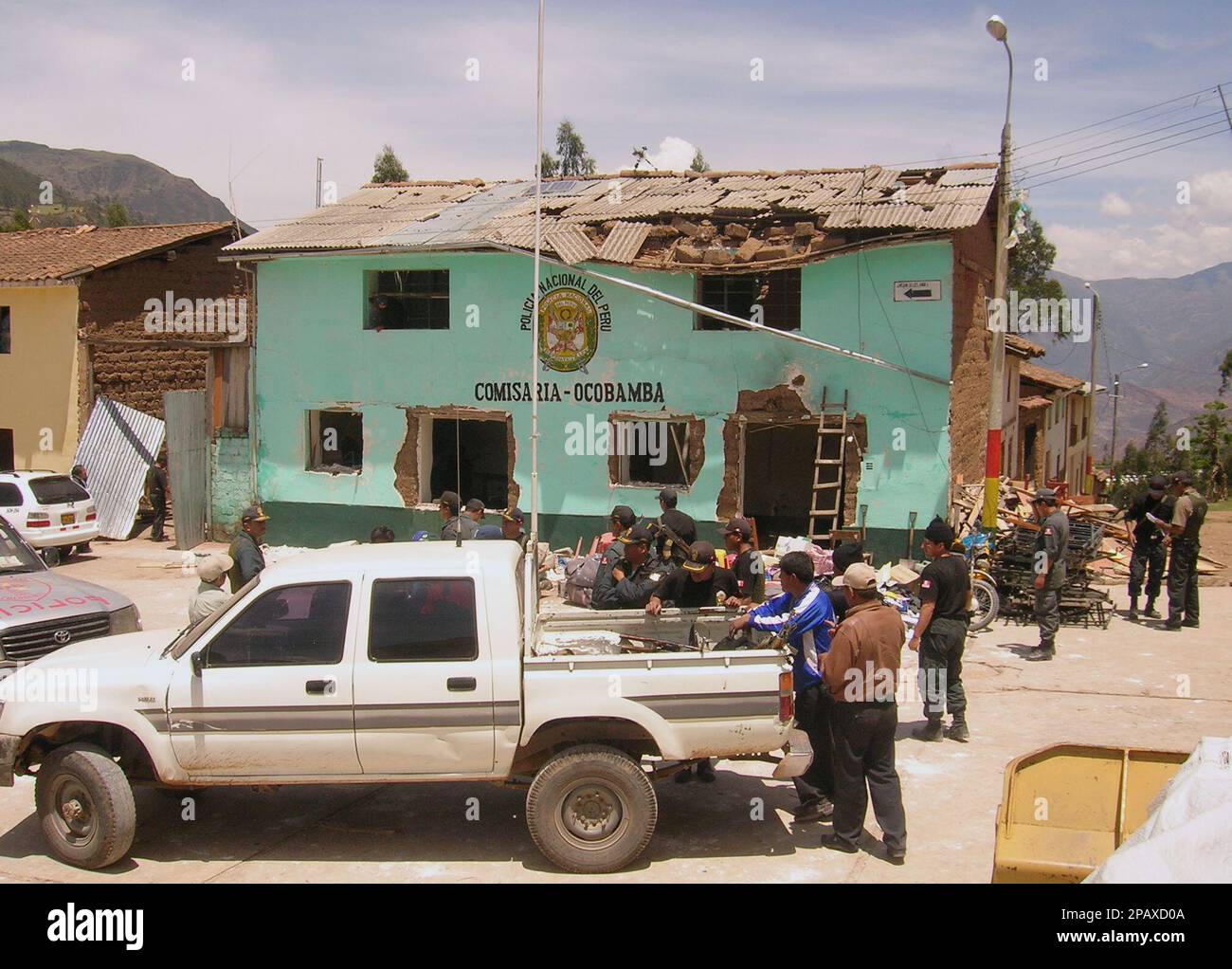 Police officers stand in front of the destroyed police station of ...