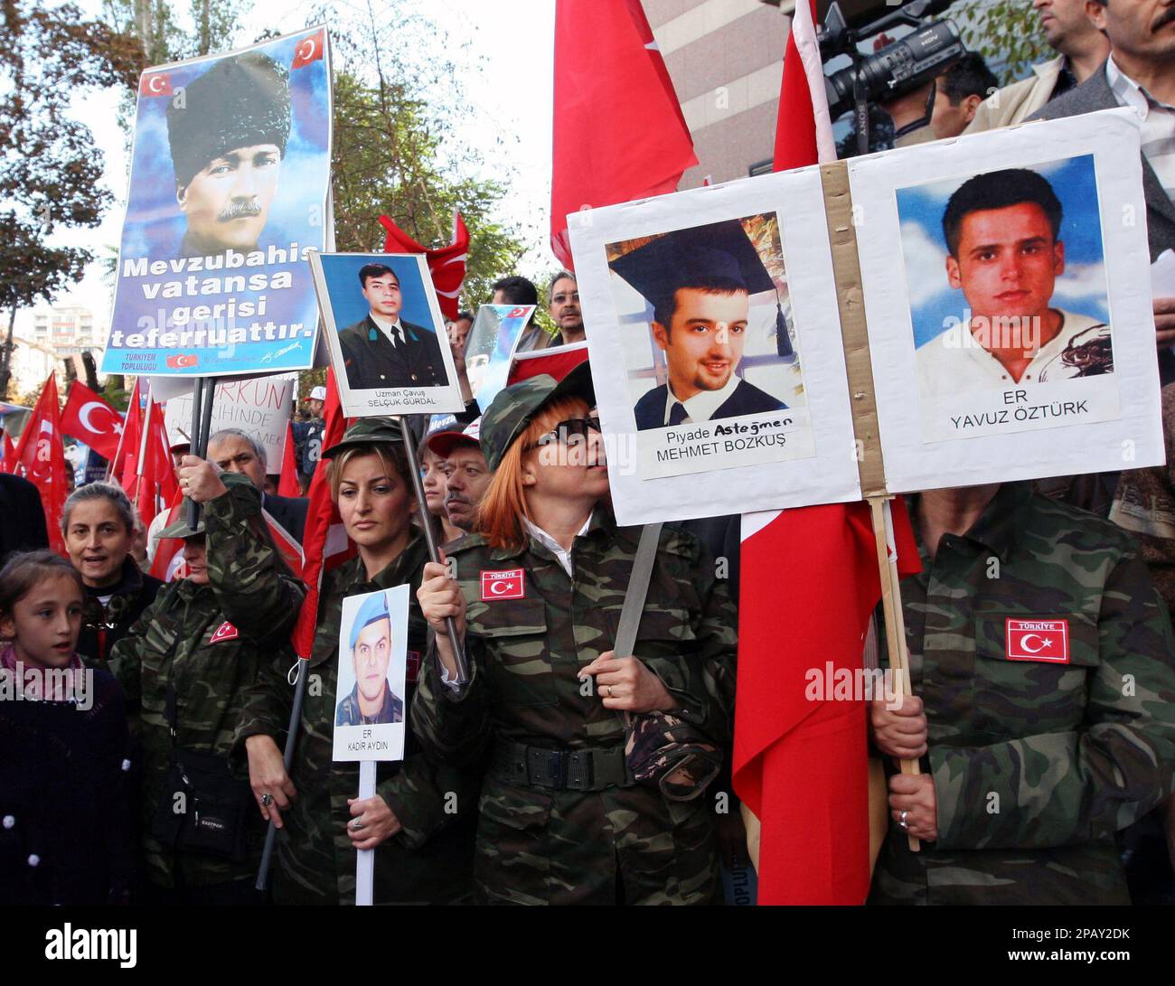 Turkish women wearing military uniforms and holding portraits of slain ...
