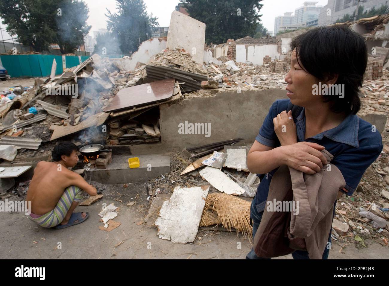 A Chinese petitioner cooking his meal as another looks on from a ...