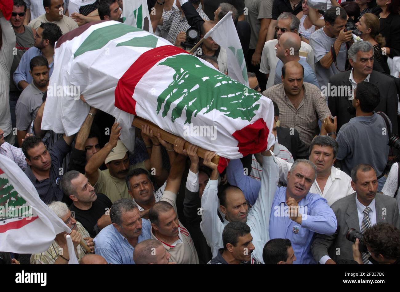 Relatives and friends carry the coffin of slain anti-Syrian lawmaker Antoine Ghanem during his ...