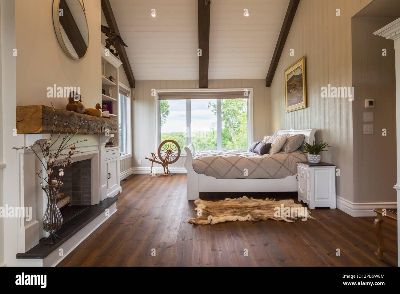 Grand lit double en traîneau peint en blanc dans la chambre principale ...