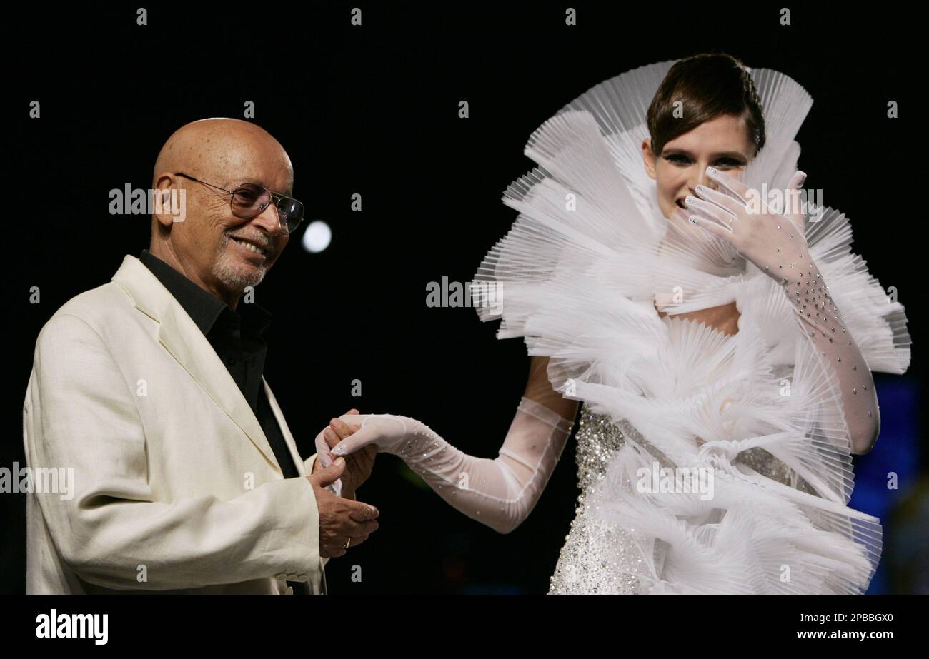 Italian designer Fausto Sarli, left, holds a model's hand at the end of ...