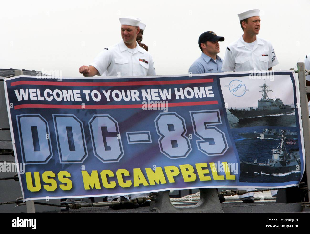 Crew members of USS Gary (FFG51) stand with a welcome banner as they ...