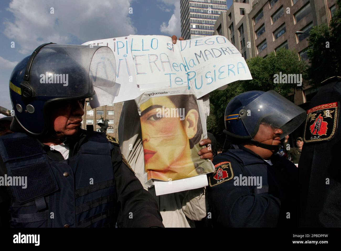 Mexican riot police hold back a protester trying to block the arrival ...