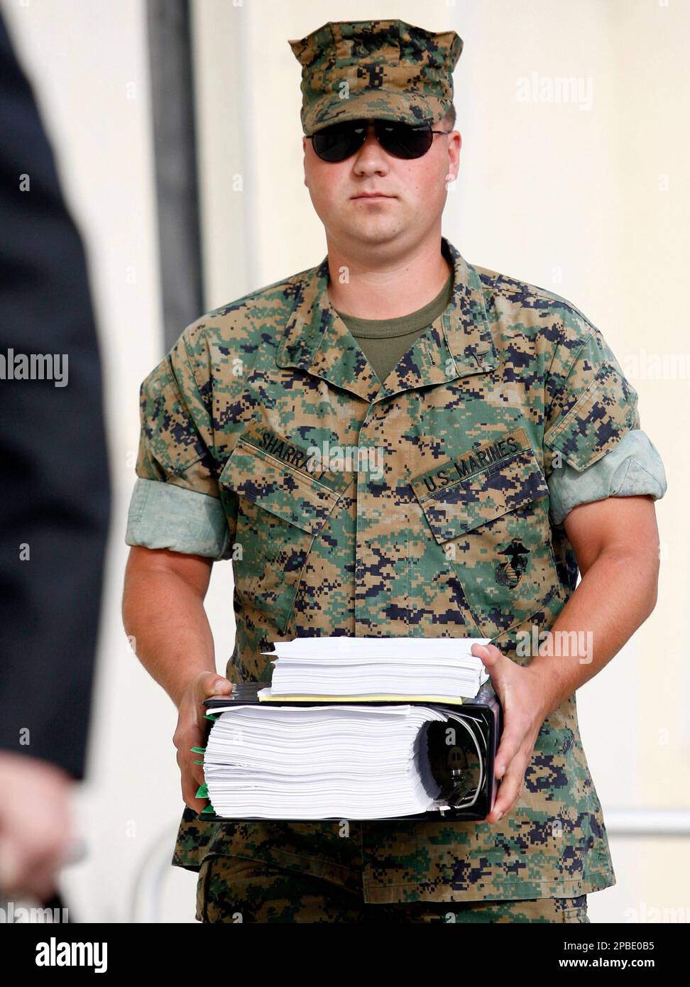 Marine Corps Lance Cpl. Justin Sharratt carries binders of documents as ...