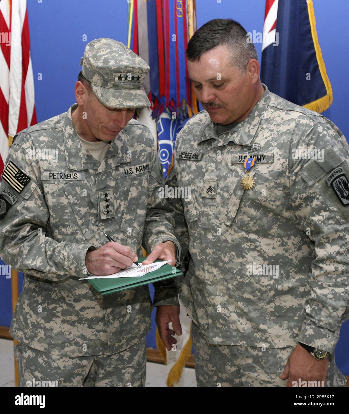 Top U.S. commander in Iraq Gen. David Petraeus, left, signs an ...