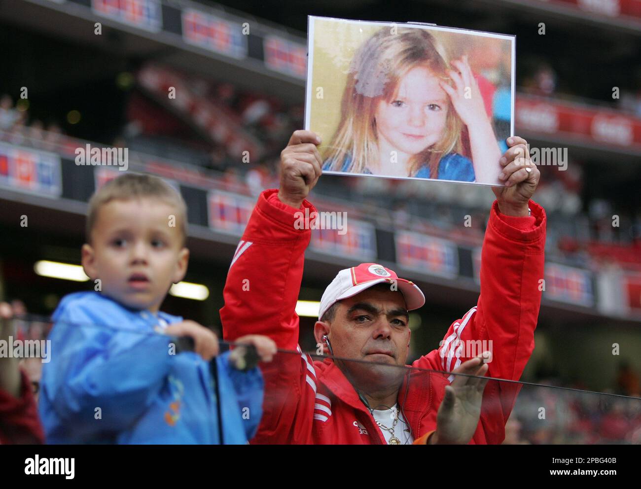 A Benfica supporter holds up a poster of missing girl Madeleine McCann ...