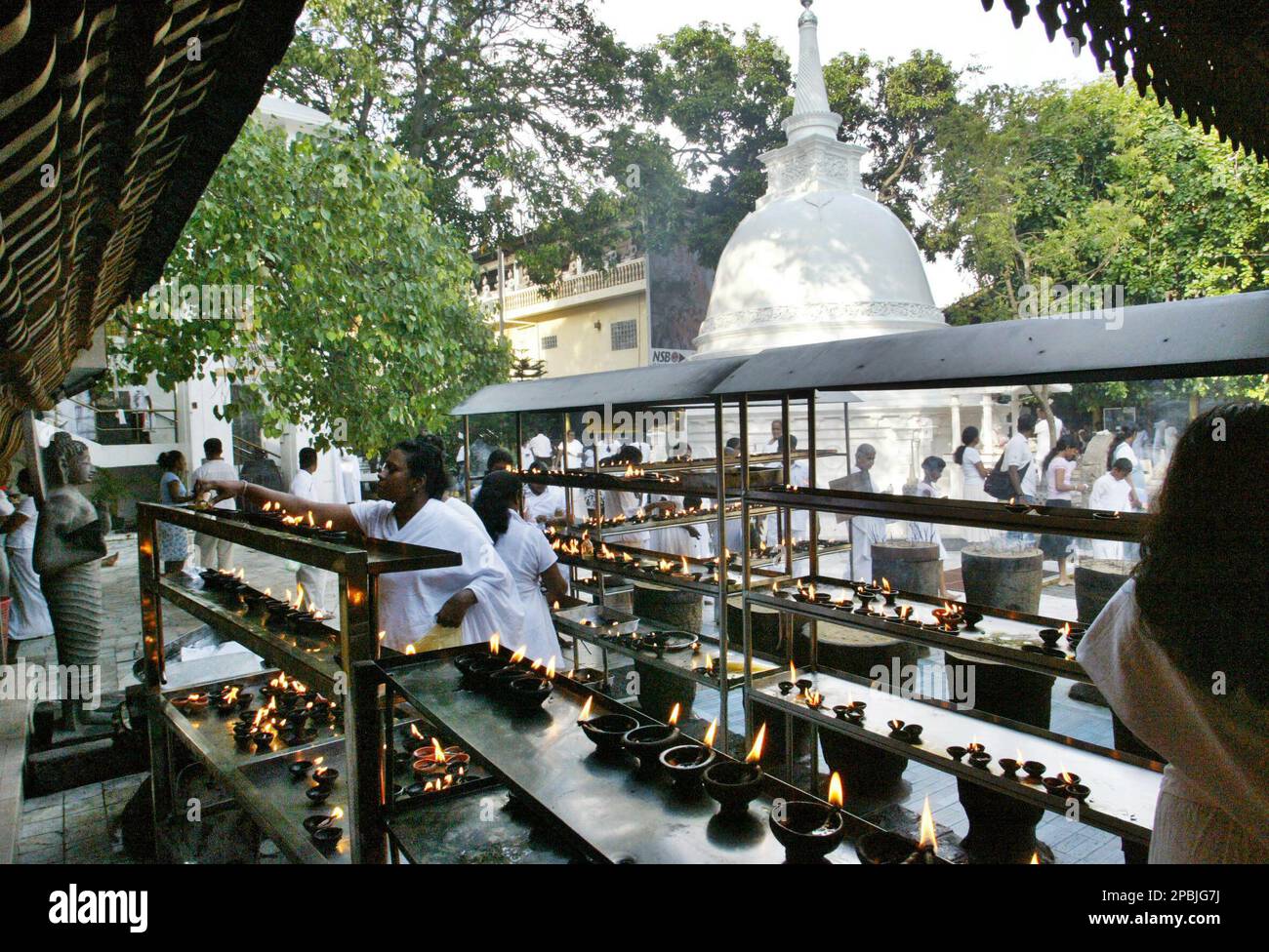 Sri Lankan Buddhists perform rituals at a Buddhist temple, to ...