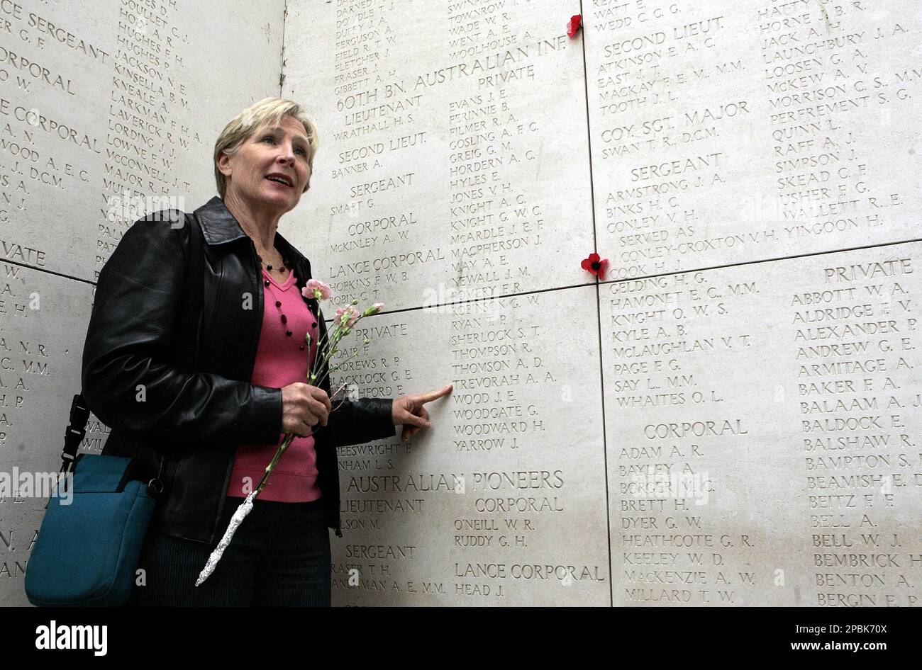 Trish Anderson from Sydney, Australia holds flowers and points to the ...