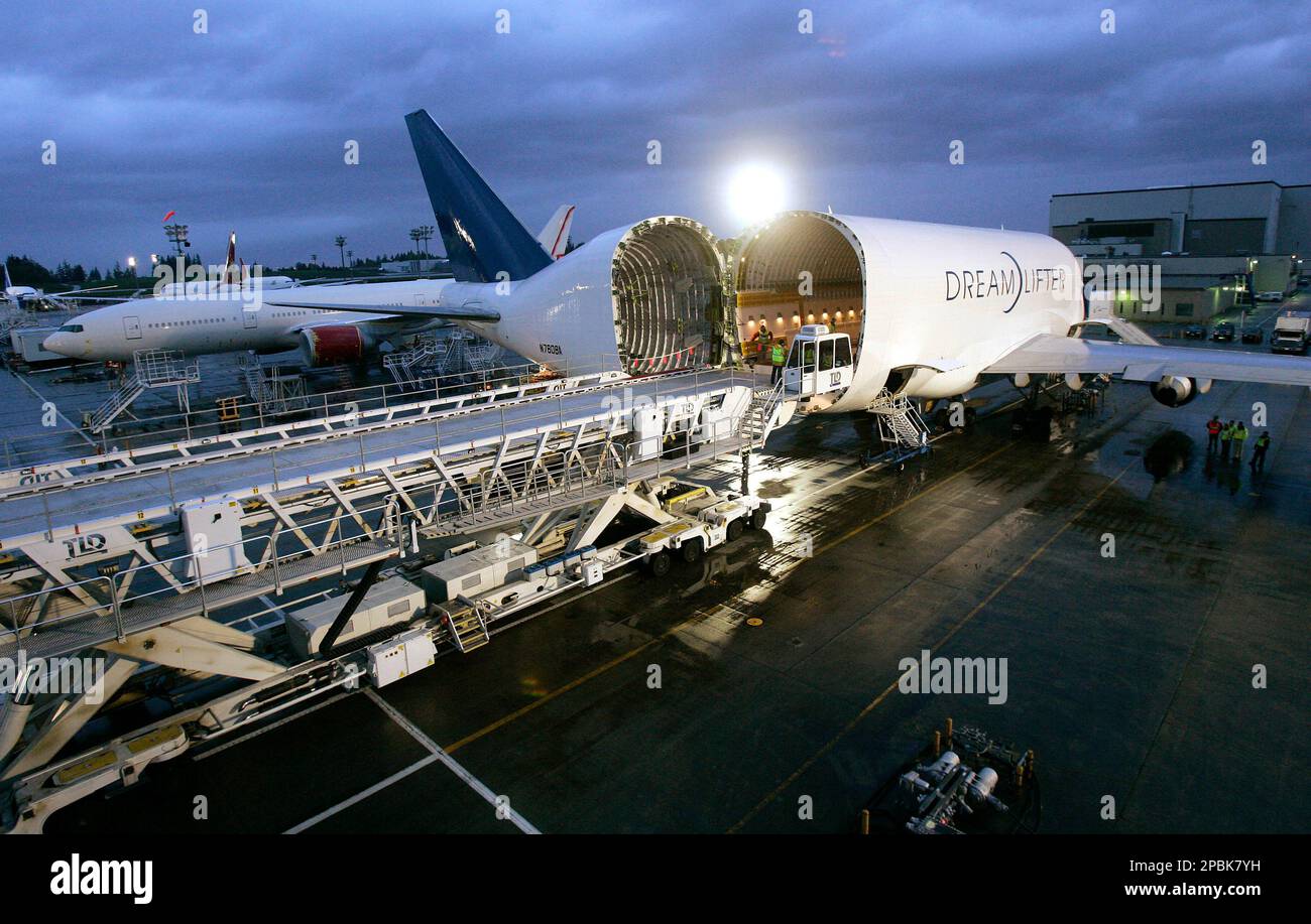 A huge cargo loader moves toward the rear of a Boeing 747 Dreamlifter ...