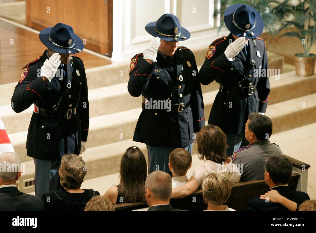 A Mississippi Highway Patrol honor guard salutes the family of Marine ...