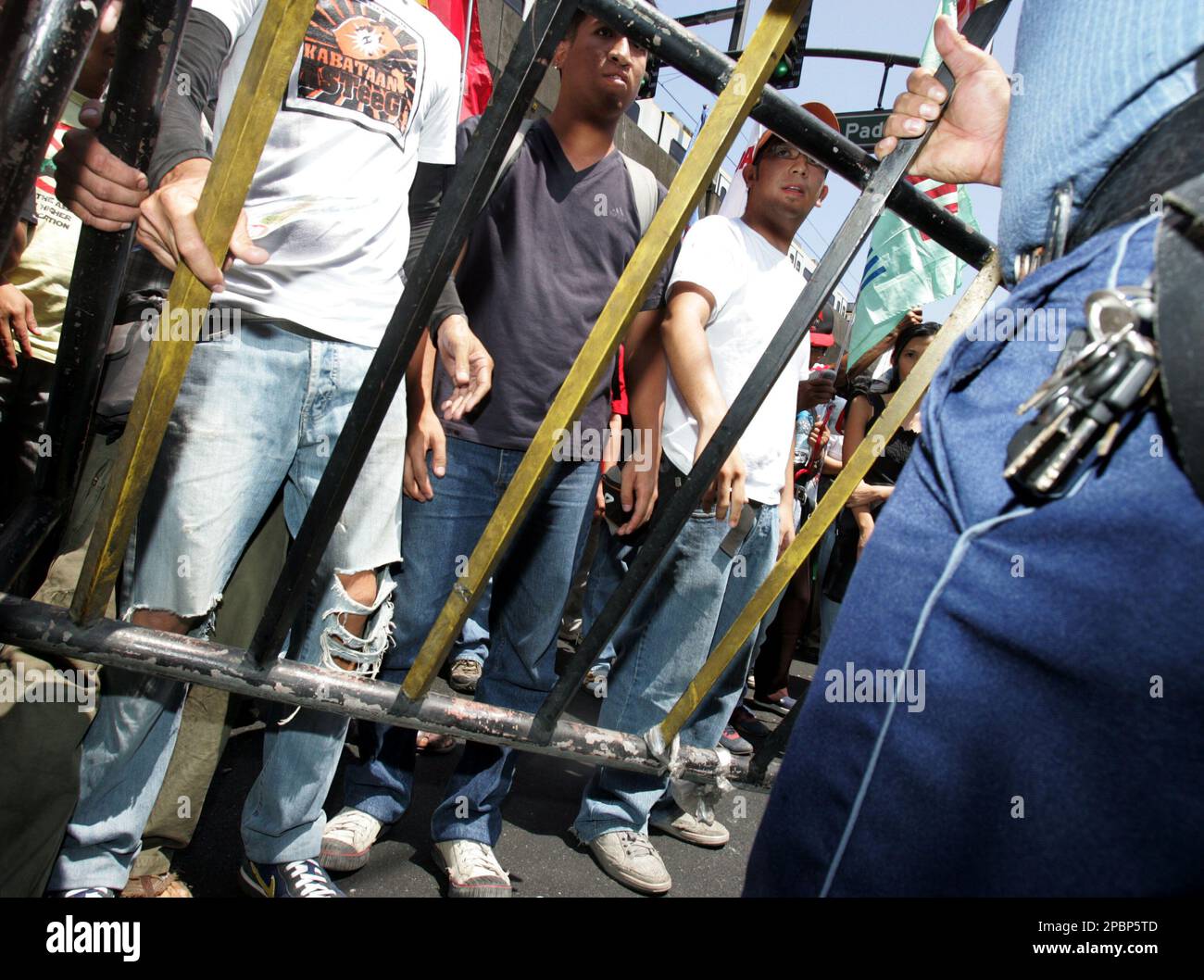 A police officer places a steel barricade in front of protesters during ...