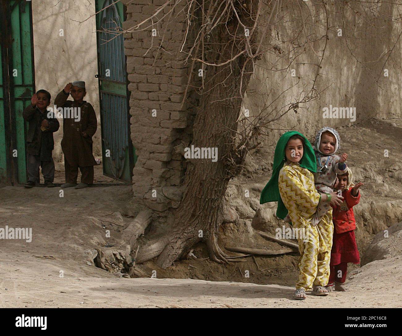 Afghan children wave to U.S. soldier patrol in Humvee (unseen) in ...