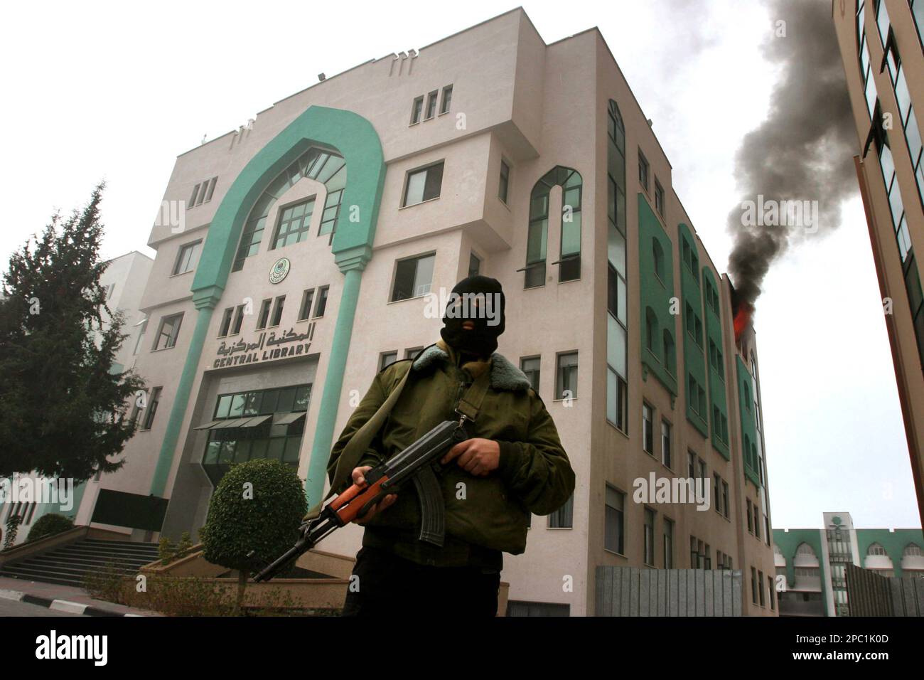 A masked Palestinian militant from the ruling Hamas party stands guard ...