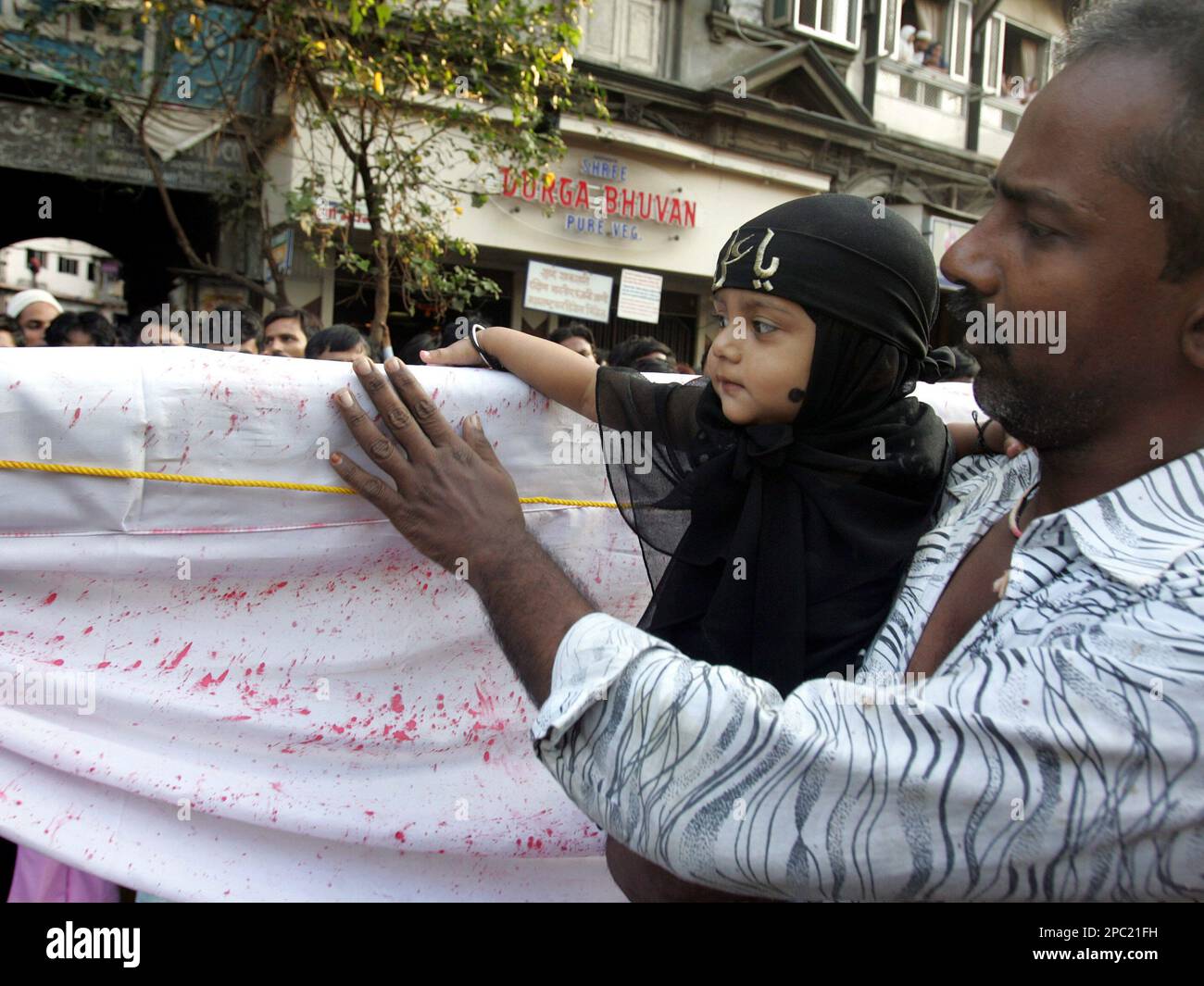 A Shiite Muslim father and daughter touch the blood smeared cloth ...