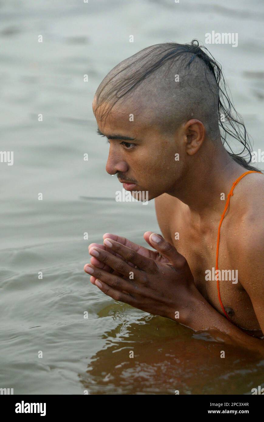 A Hindu holy man, prays after taking a holy dip at the confluence of ...