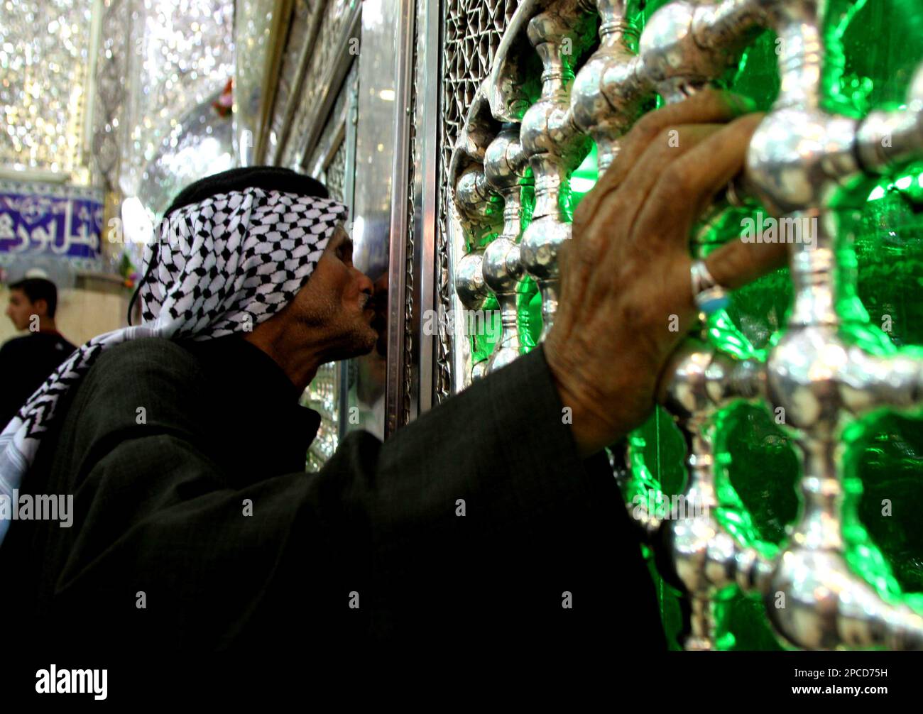 A man kisses the tomb of Muslim ibn Aqeel, a cousin and supporter of ...