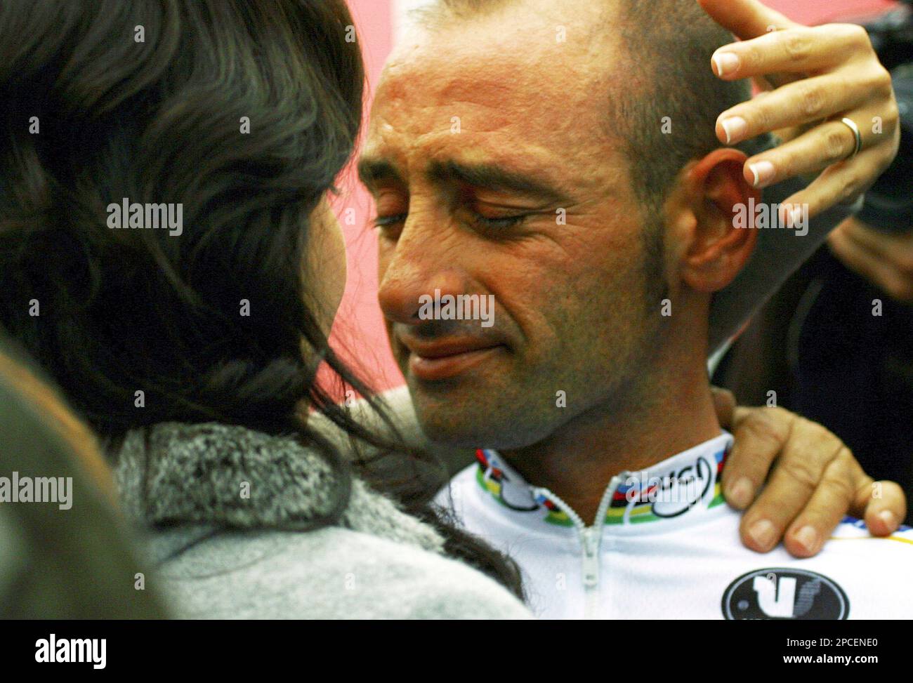 World and Olympic champion Paolo Bettini, of Italy, is comforted by his ...