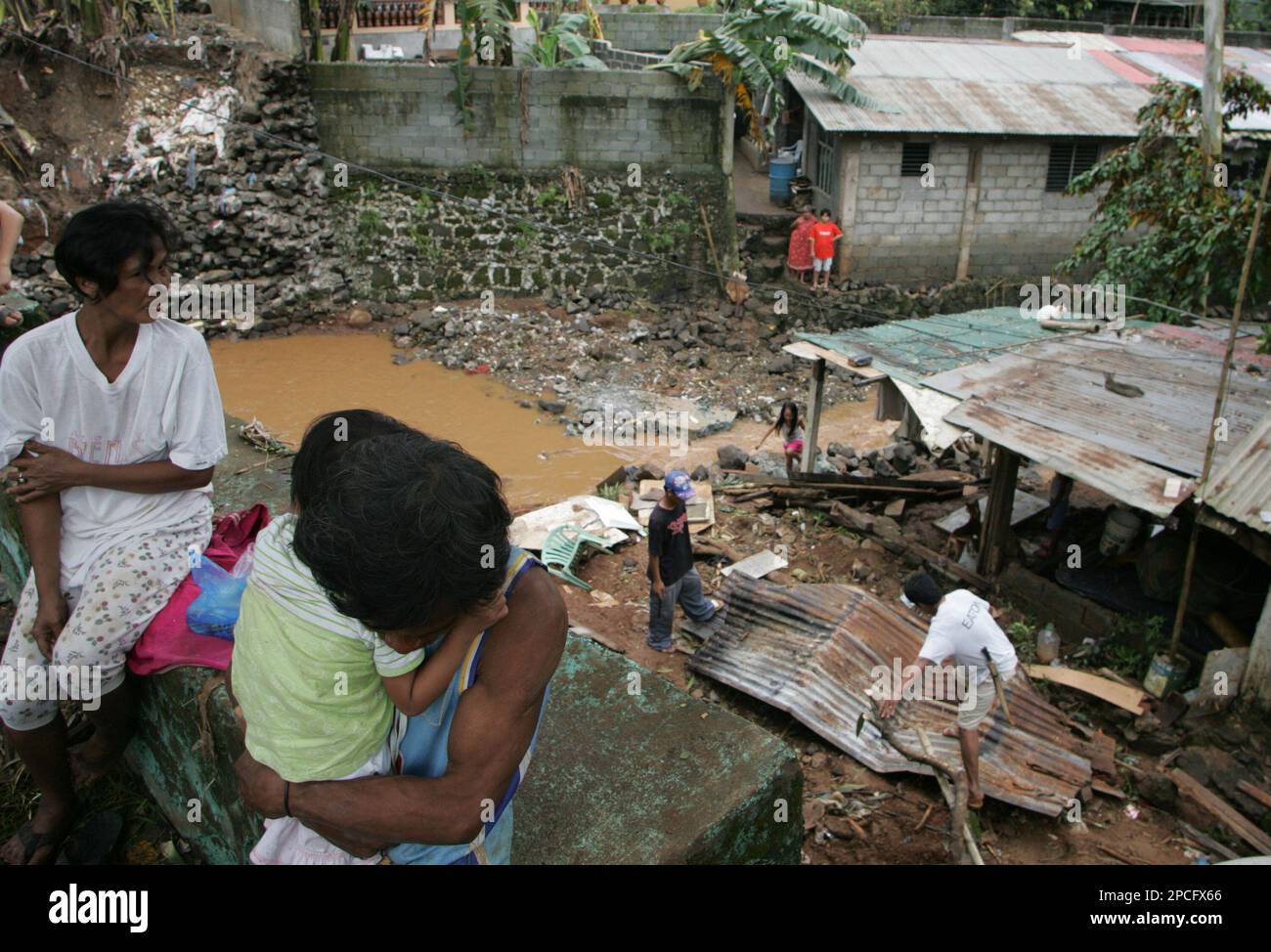 Flash flood survivor Carlito Legaspi cuddles his daughter Catherine as ...