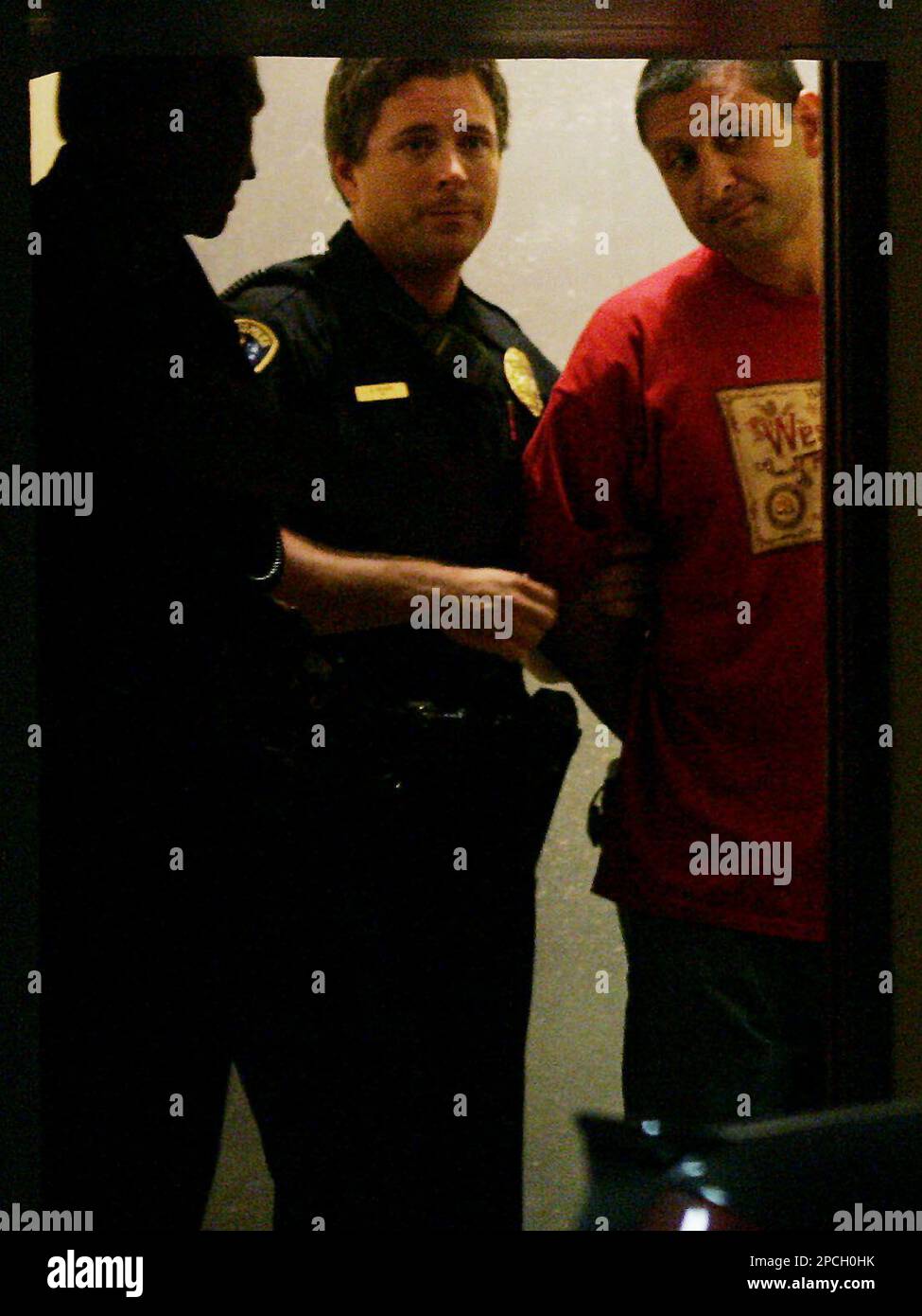 San Diego Police officers escort Assad "Sam" Suleiman in handcuffs ...