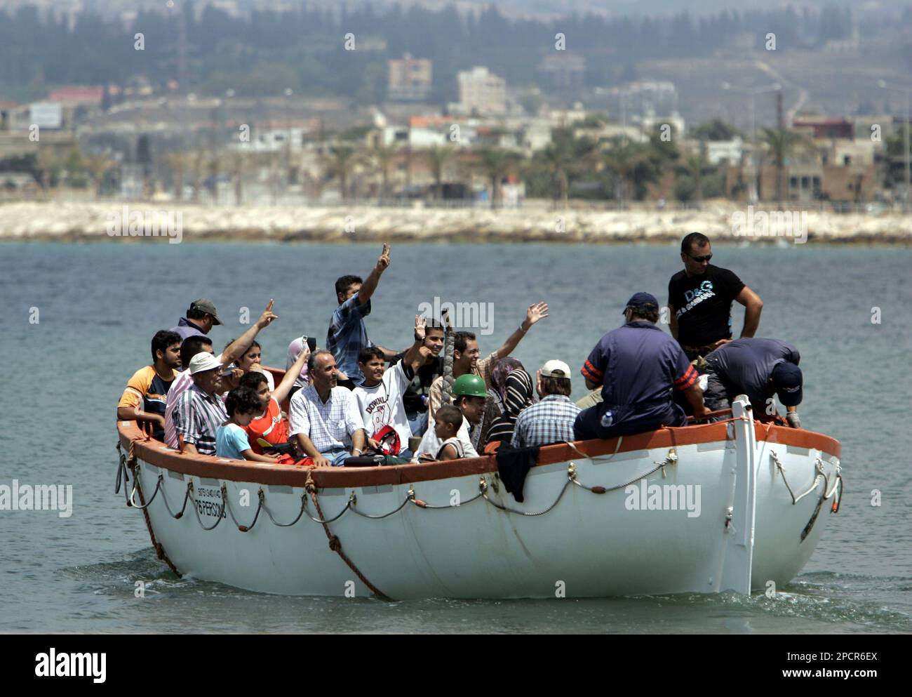 Lebanese with foreign passports wave from a boat heading towards the ...