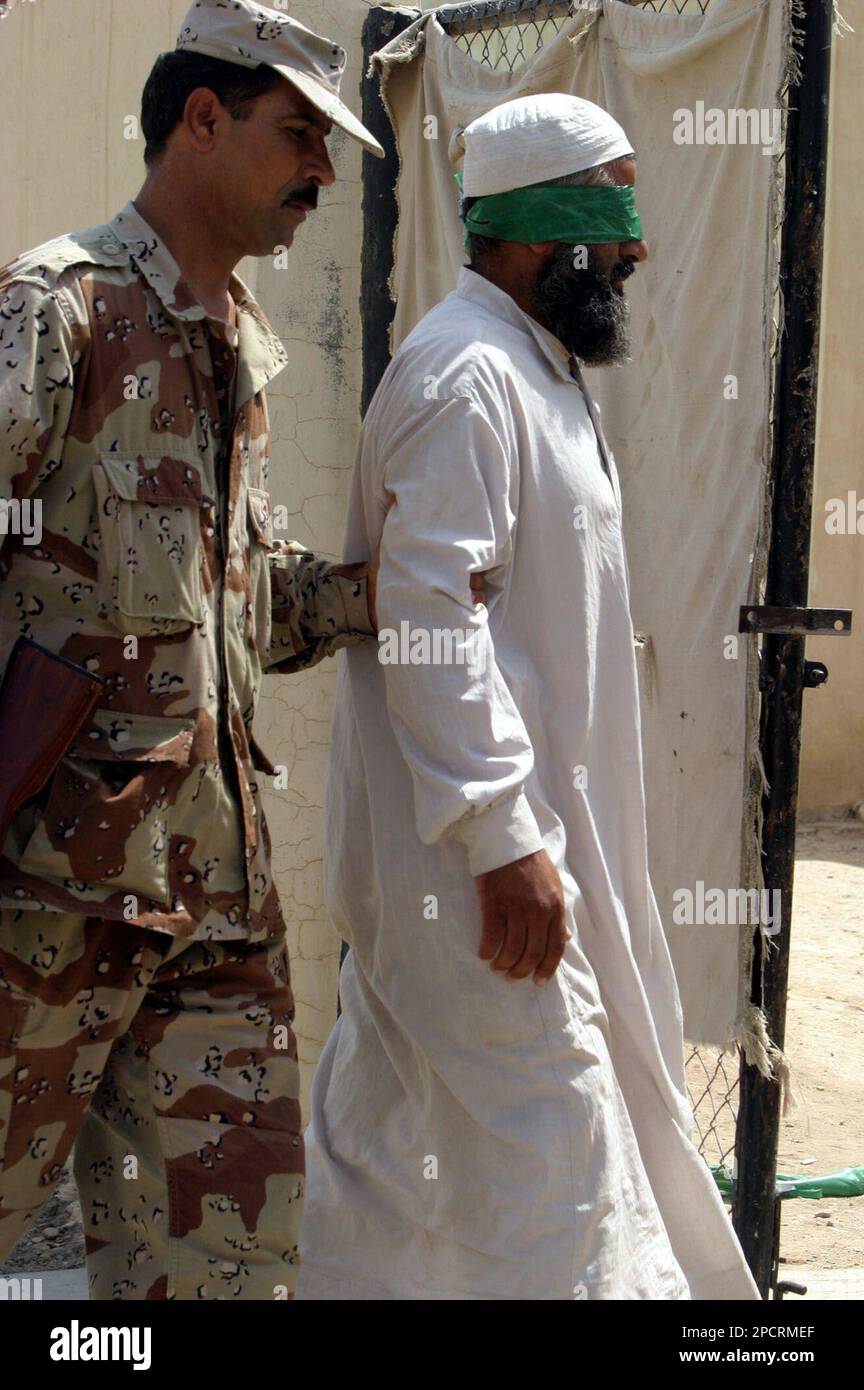 Iraqi troops escort blindfolded suspects arrested during a raid ...