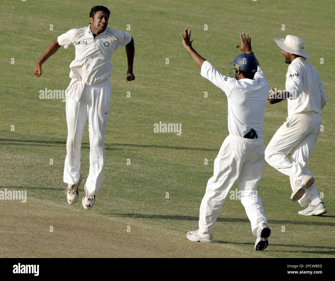 India's bowler Anil Kumble, center, jumps into the air as he celebrates ...