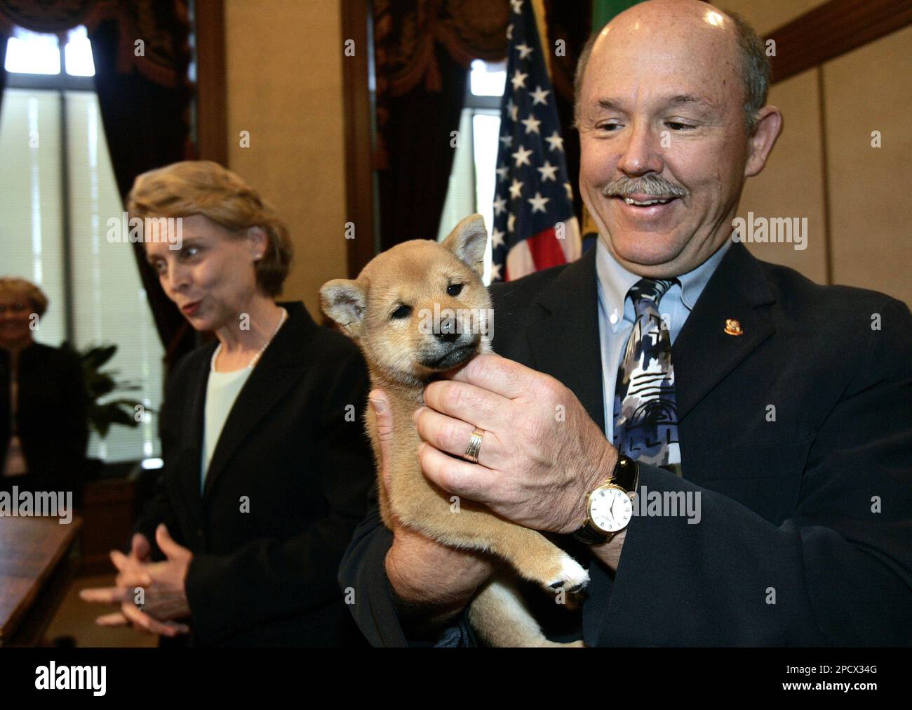Mike Gregoire, right, holds the new family puppy "Trooper" as Gov ...