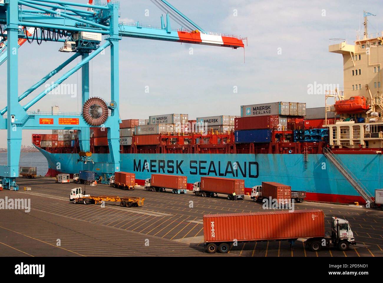 ** FILE ** Trucks carrying shipping containers line up to be loaded ...