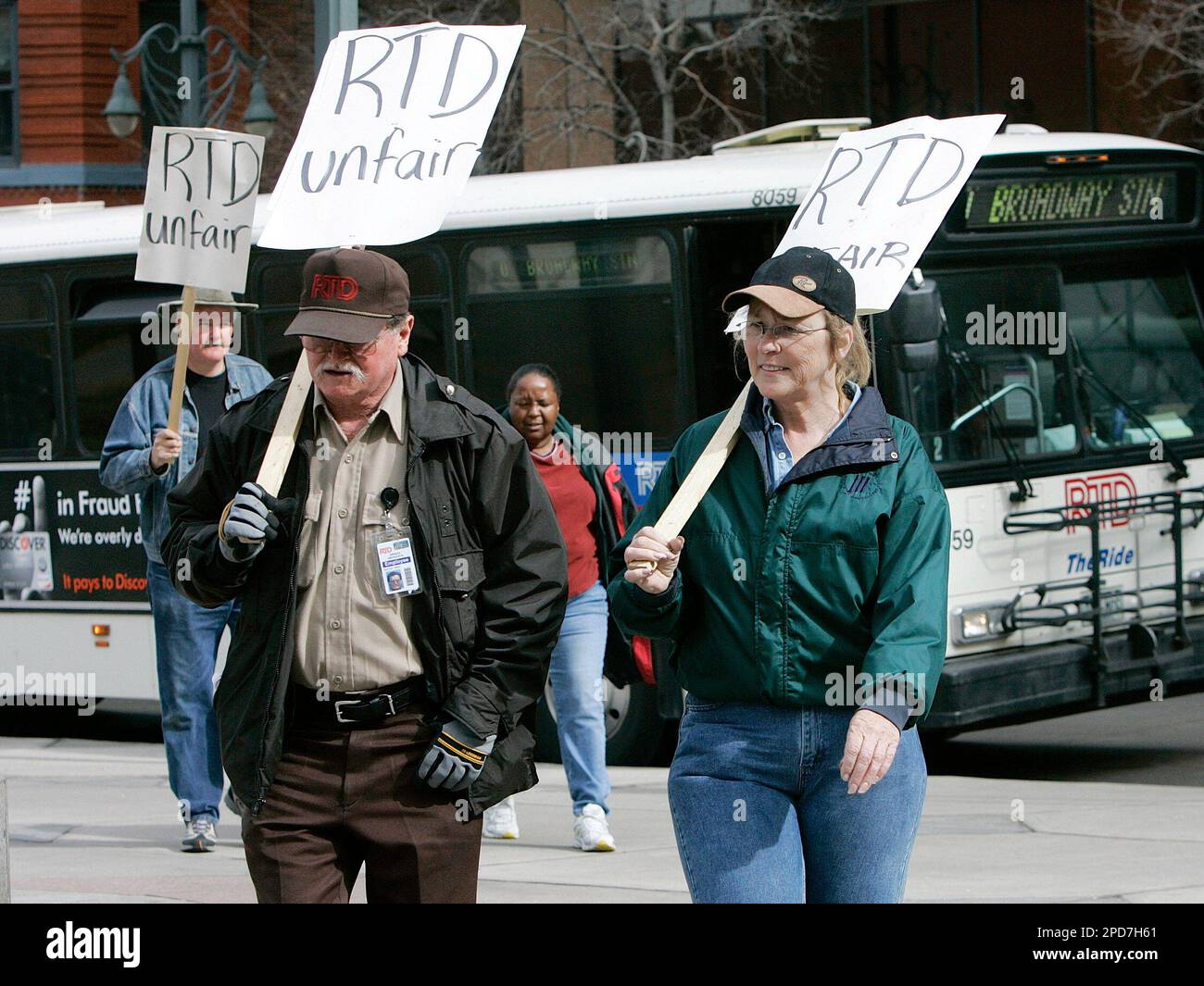 Striking transit workers walk the picket line with a RTD bus in the ...