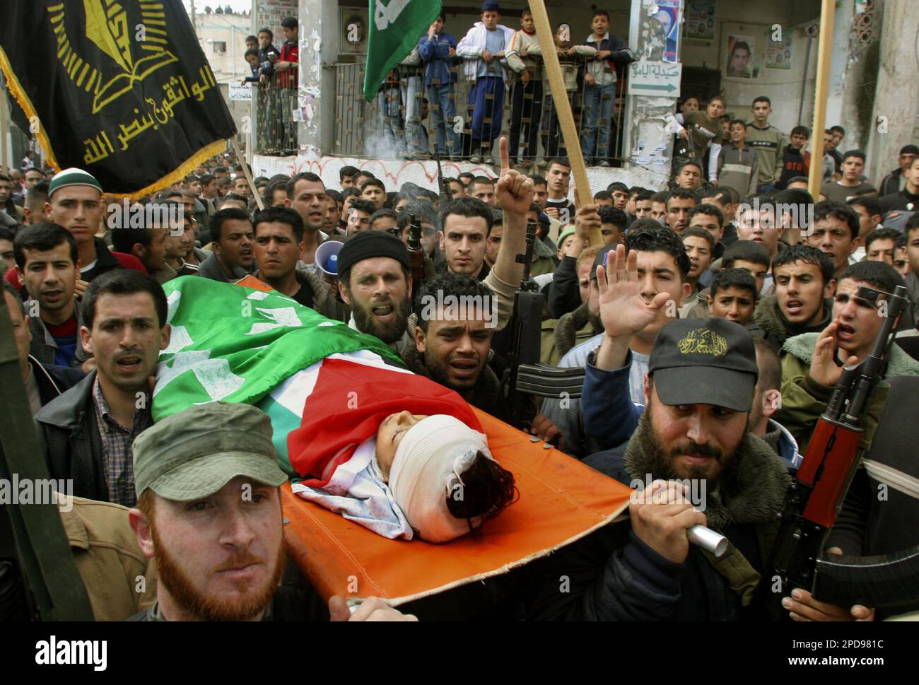 Palestinians and gunmen from the Islamic Jihad carry the flag-wrapped ...