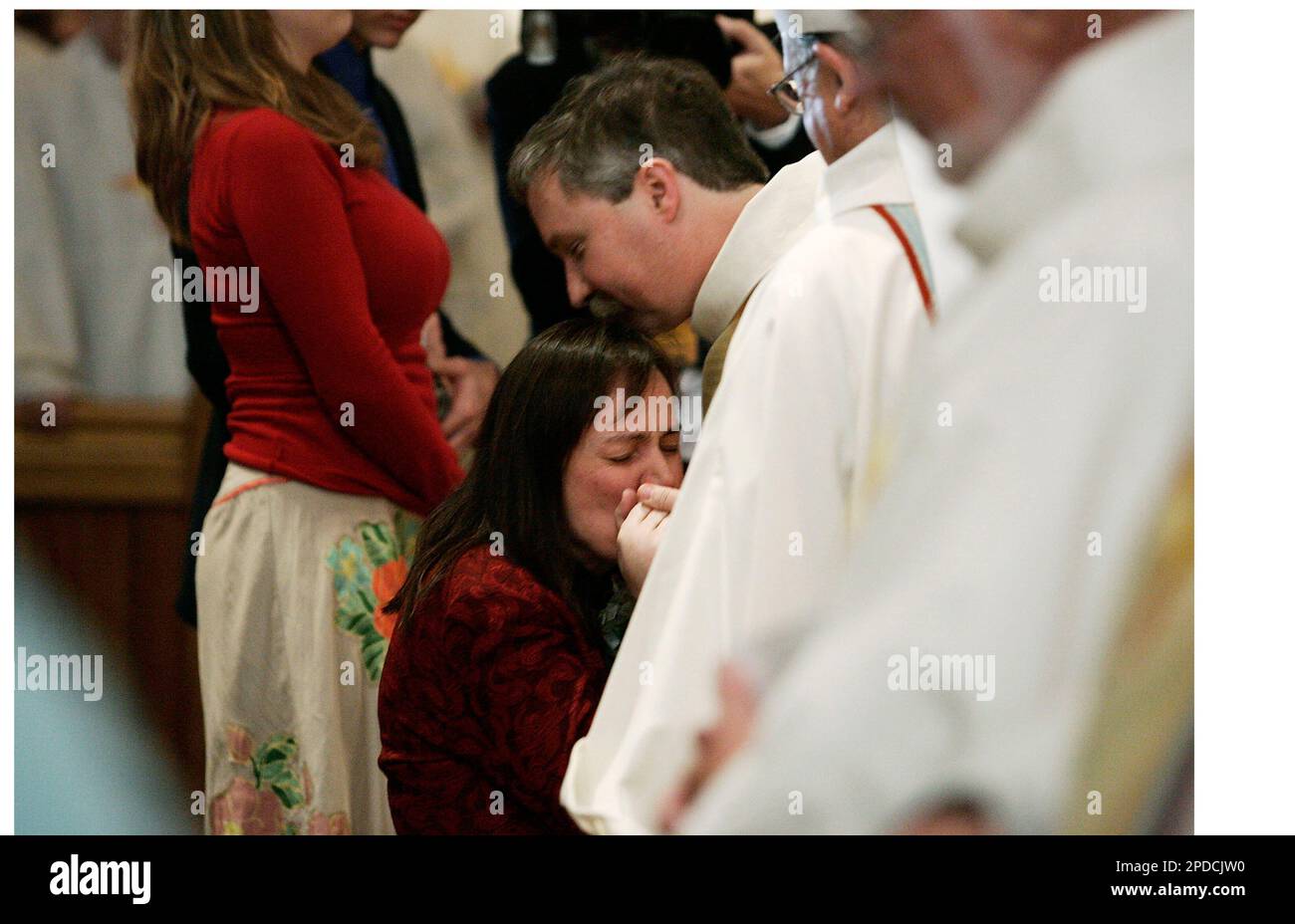 Father Gregory Elder, a former Episcopalian priest who converted to Catholicism, kisses his wife ...