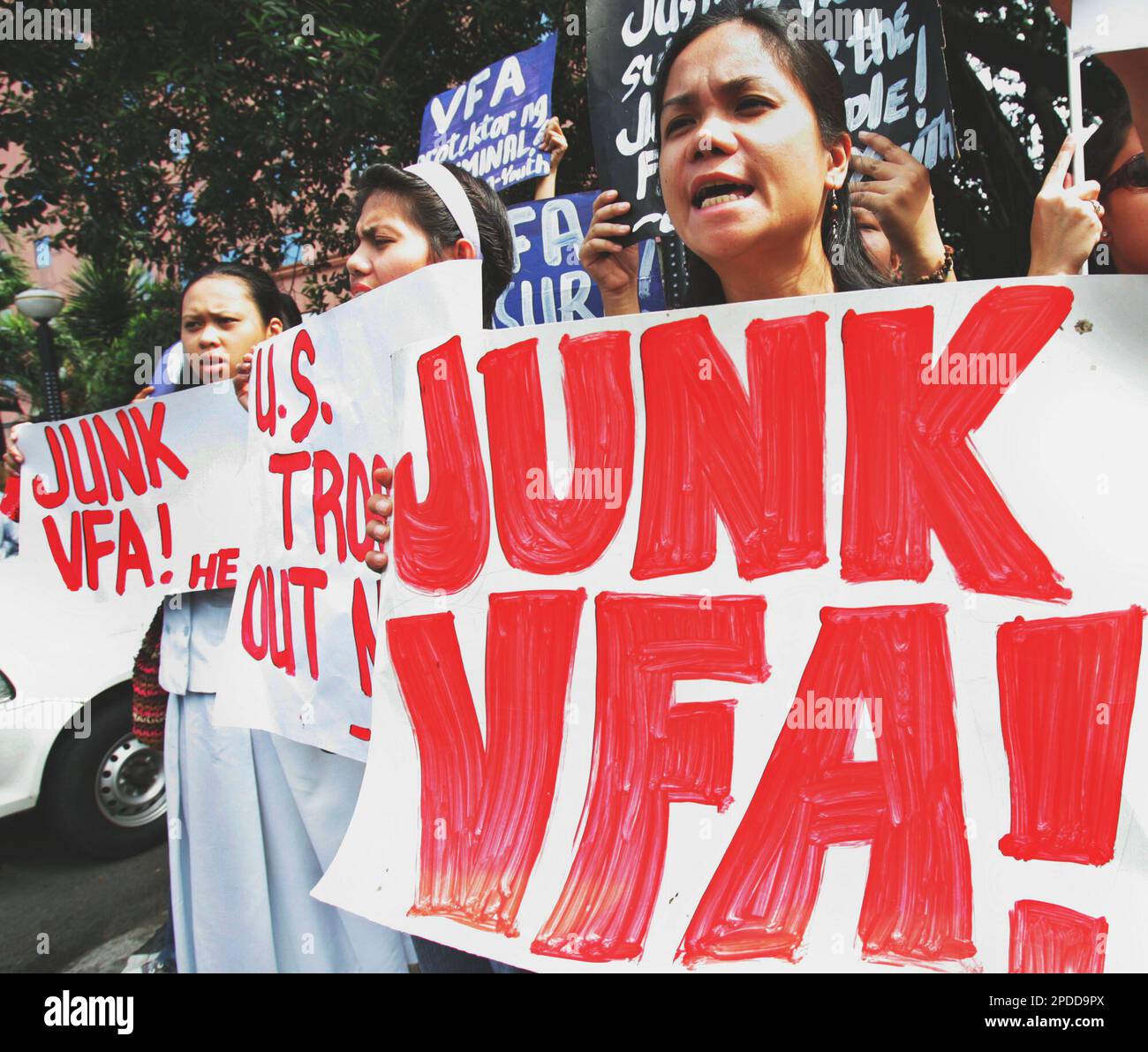 Protesters display their placards as they shout slogans during a rally ...