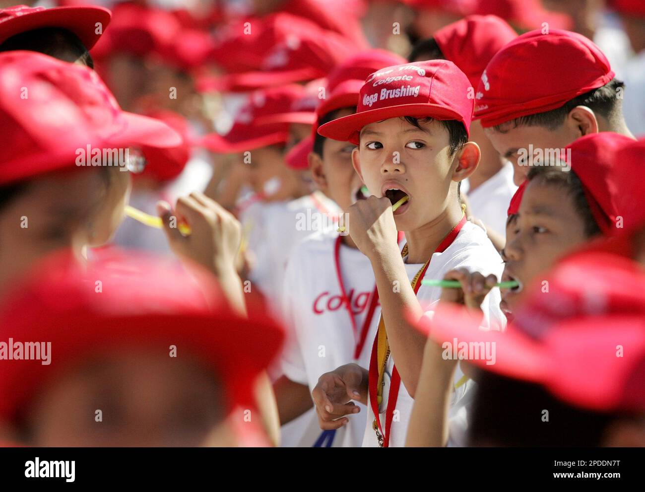 A Filipino student brushes his teeth with others at Manila's Rizal Park ...