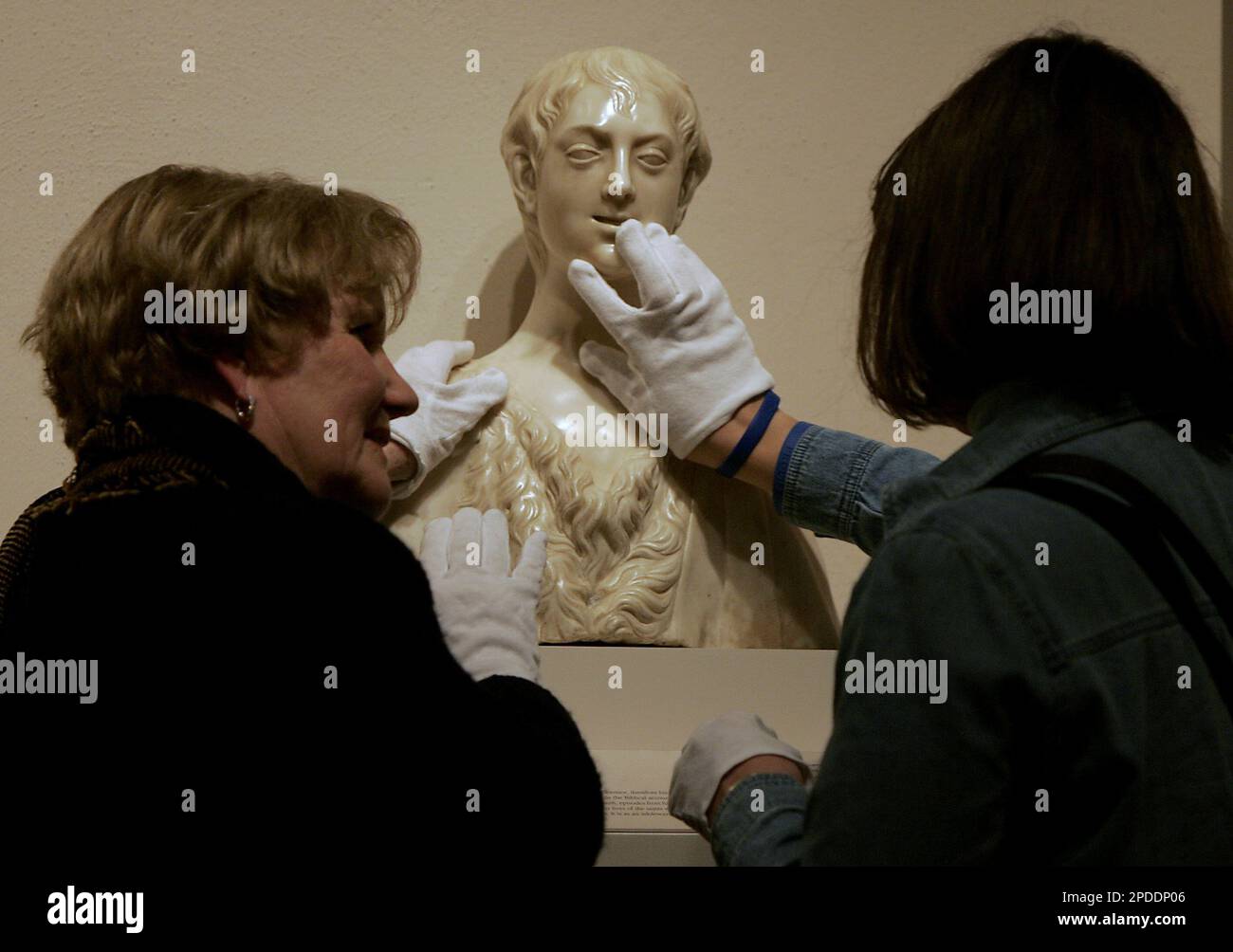 Docent Carolyn Reintjes, left, talks to Tina Jenkins as she feels a ...