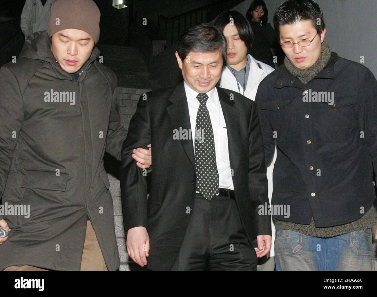 South Korean stem cell pioneer Hwang Woo-Suk, center, is escorted by ...
