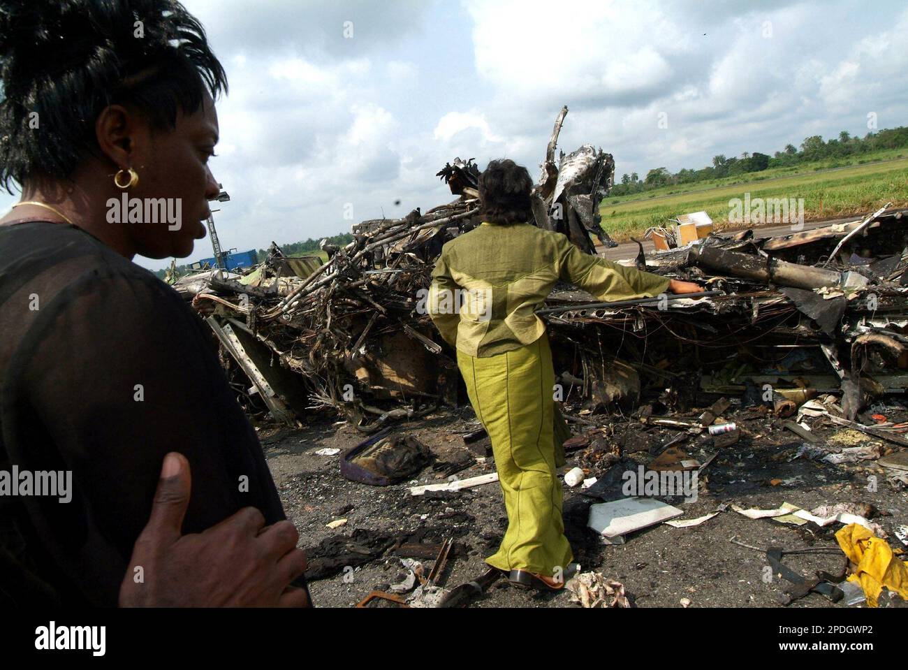 Ify Ilabor, left, who lost her three children is consoled as she walks ...