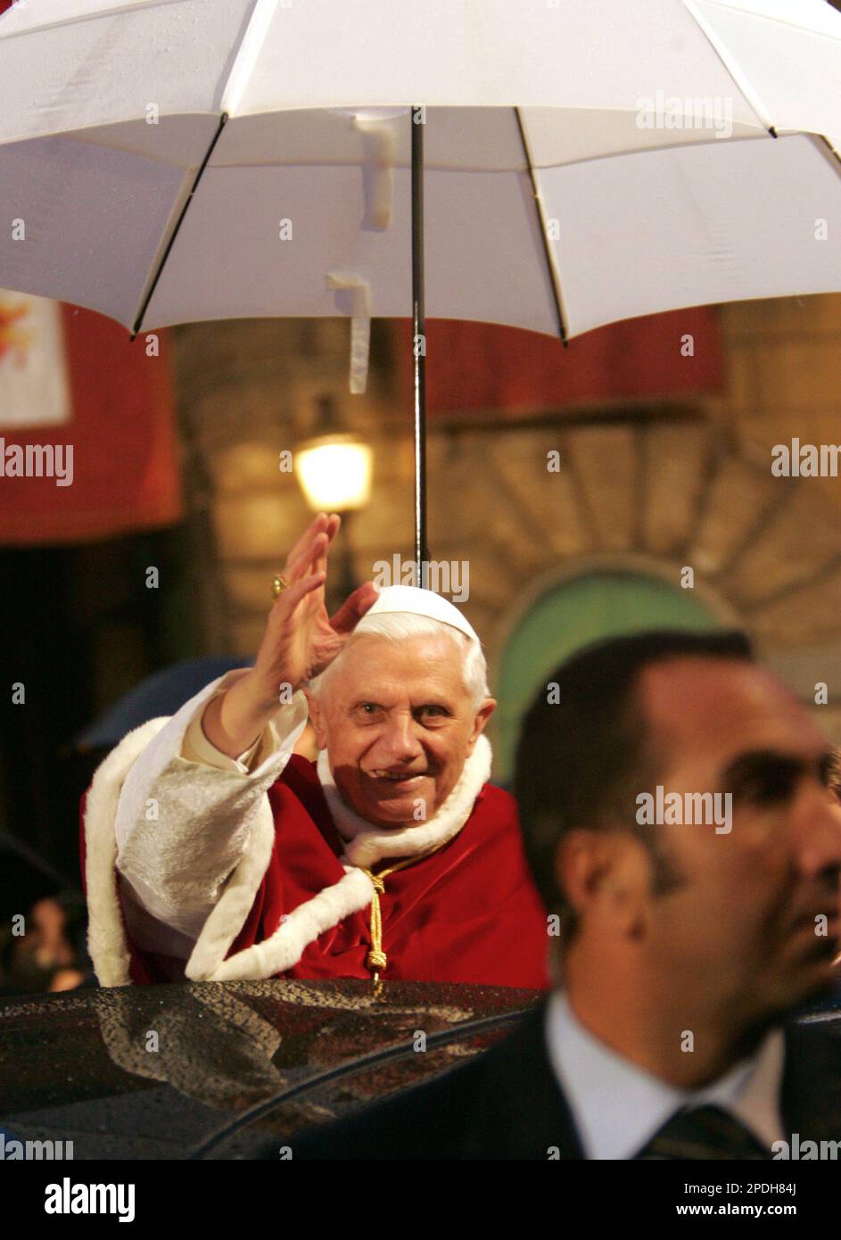 Pope Benedict XVI gives his blessing as he leaves in his open-top car ...