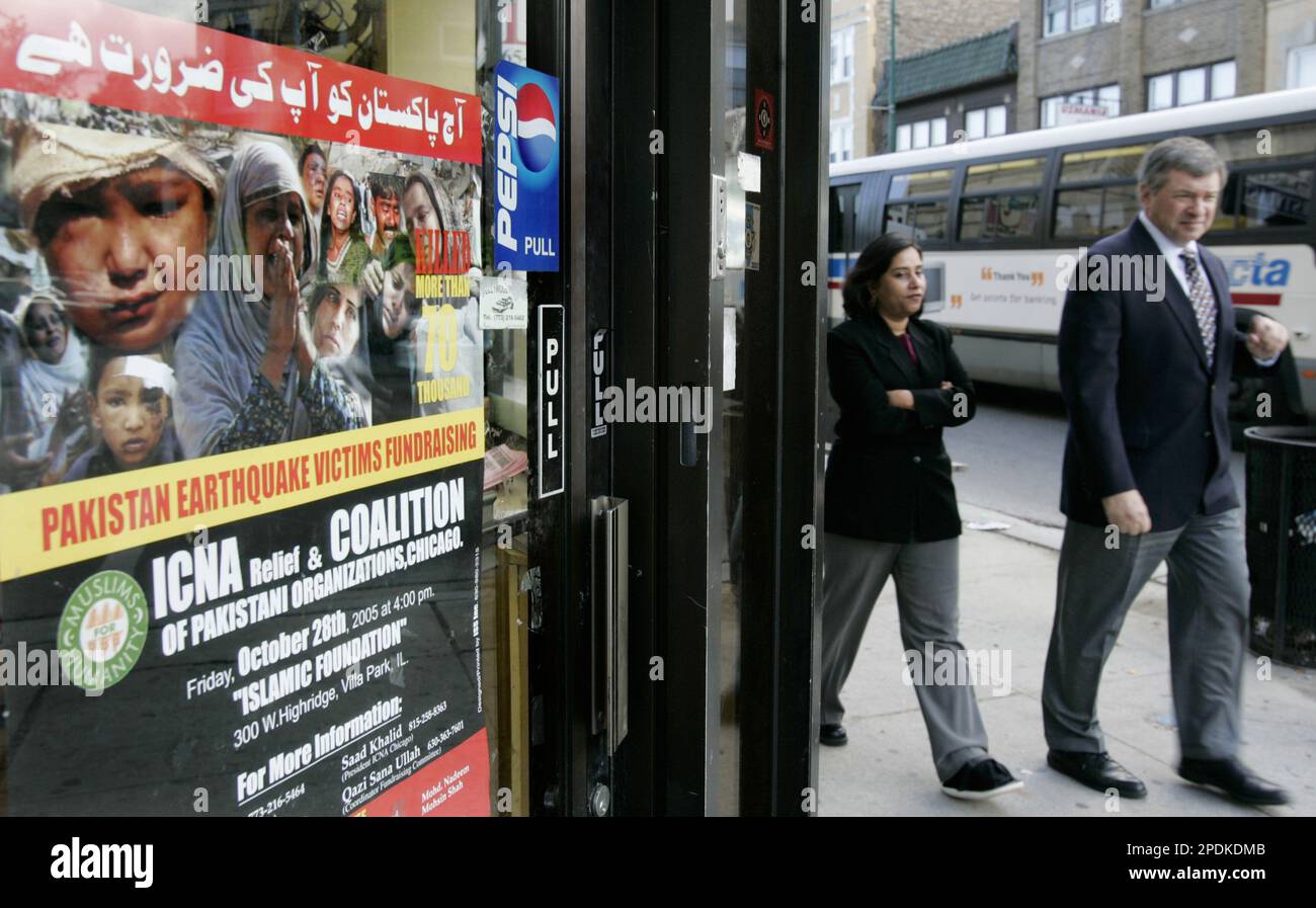 Pedestrians walk past a Pakistan Earthquake Relief Fund poster at a Chicago Pakistani restaurant ...