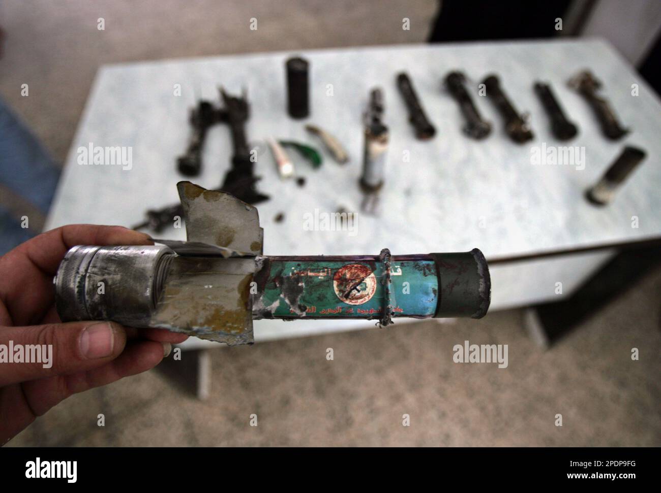 A Palestinian police officer displays a used rocket shell with an ...