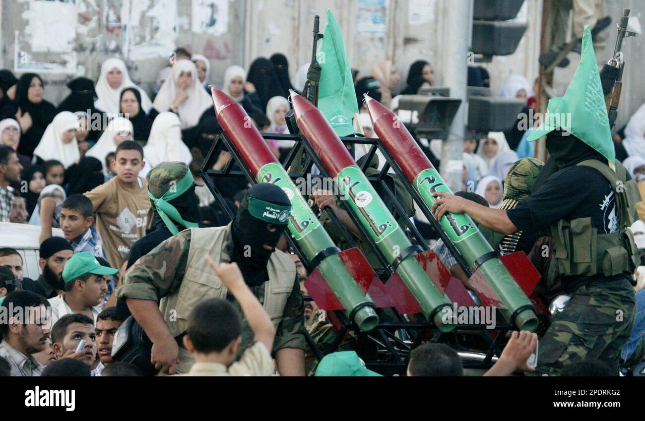 Masked Palestinian Hamas militants display their weapons during a parade in Gaza City, Sunday ...