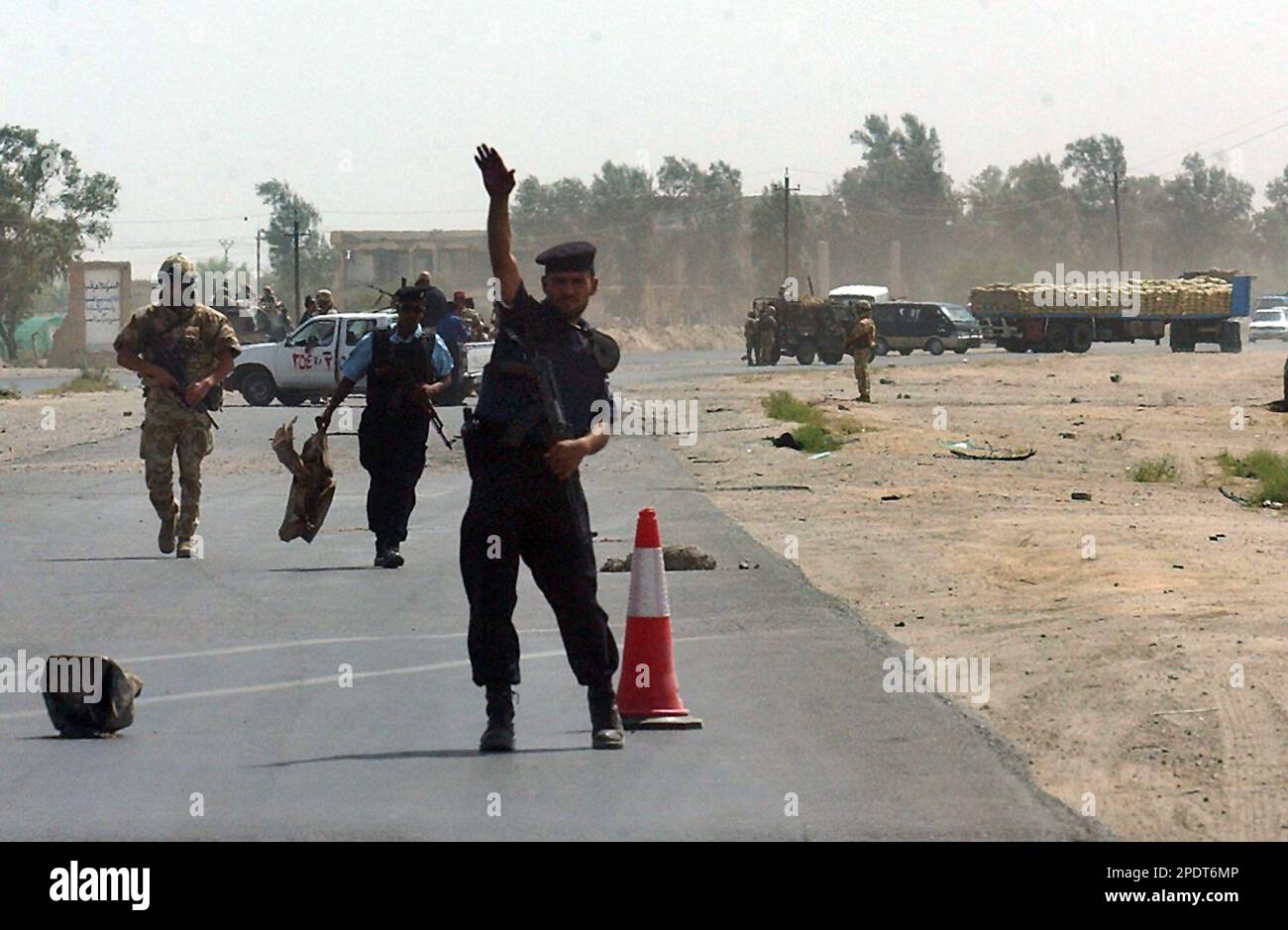 British soldiers and Iraqi police block off the area around a wrecked ...