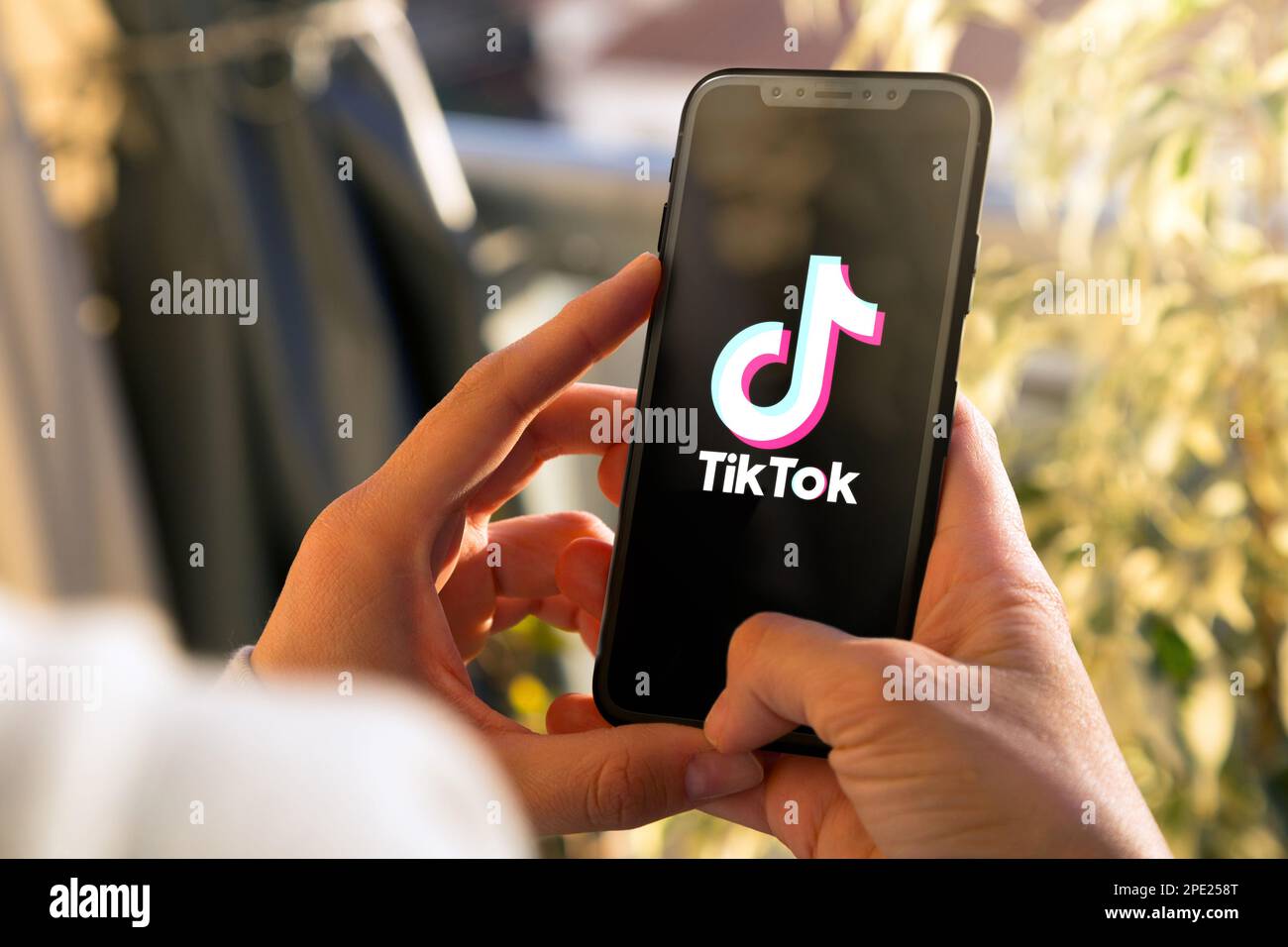 Tiktok sur l'écran du téléphone portable. Jeune femme tenant un Smart Phone avec l'application ...