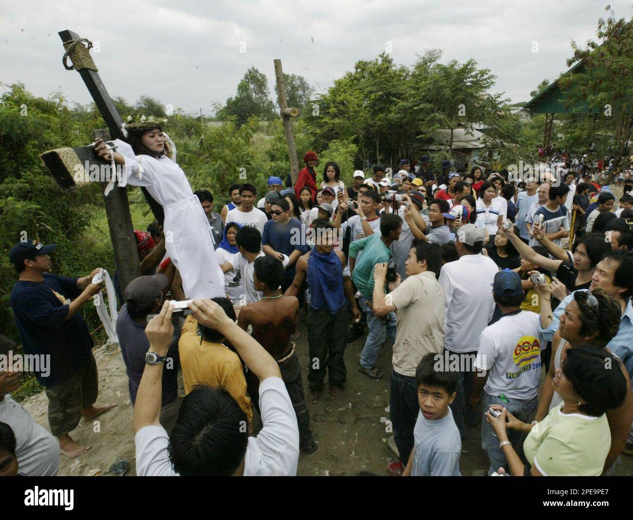 Tourists take photos of Mary Jane Mamangon, 30, as she stays nailed on ...