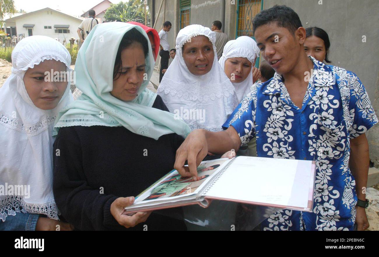 Rizal Shahputra, 20, right, shows a photo album containing newspaper ...