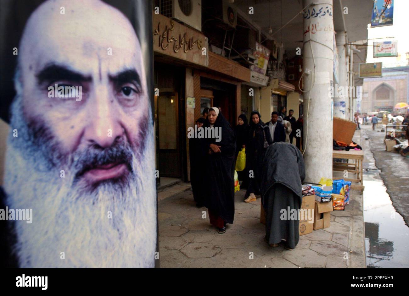 ** FILE ** People walk past a poster of Shiite cleric Grand Ayatollah ...