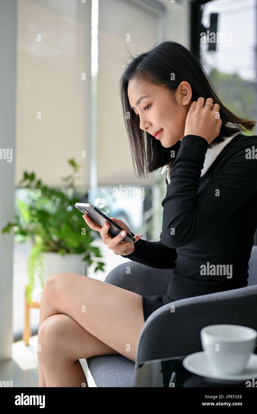 Portrait d'une femme d'affaires asiatique belle et belle millénaire en robe noire décontractée ...
