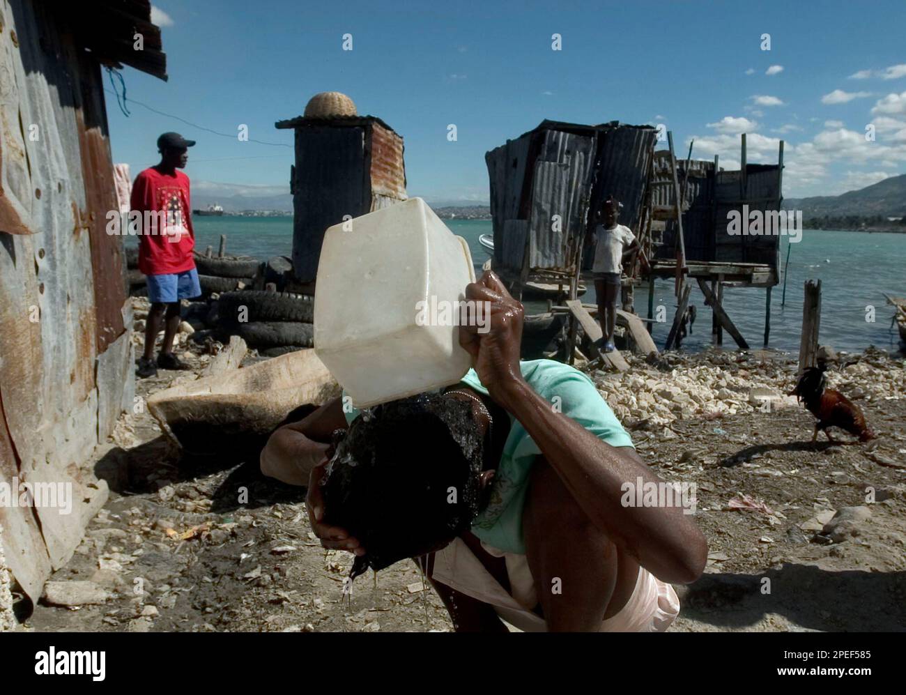An Haitian woman washes her hair outside her house in Carrefour slum ...