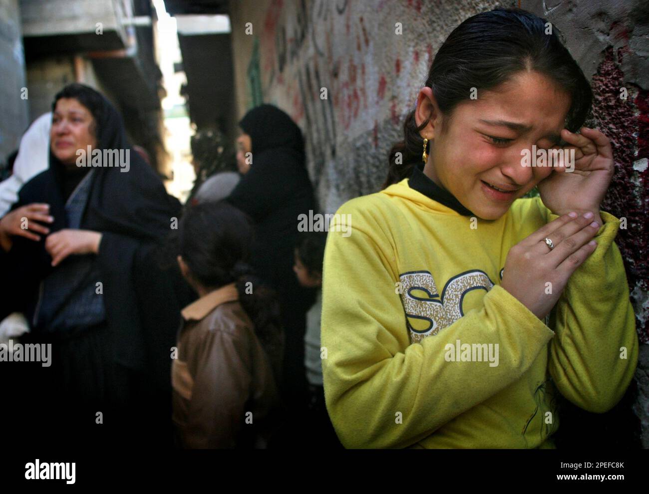 Nine-year-old Ahlam Al-Sadek cries outside the family house prior to ...
